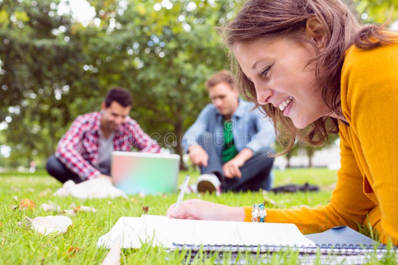 Student Writing Notes with Two Using Laptop in Park Stock Image - Image ...