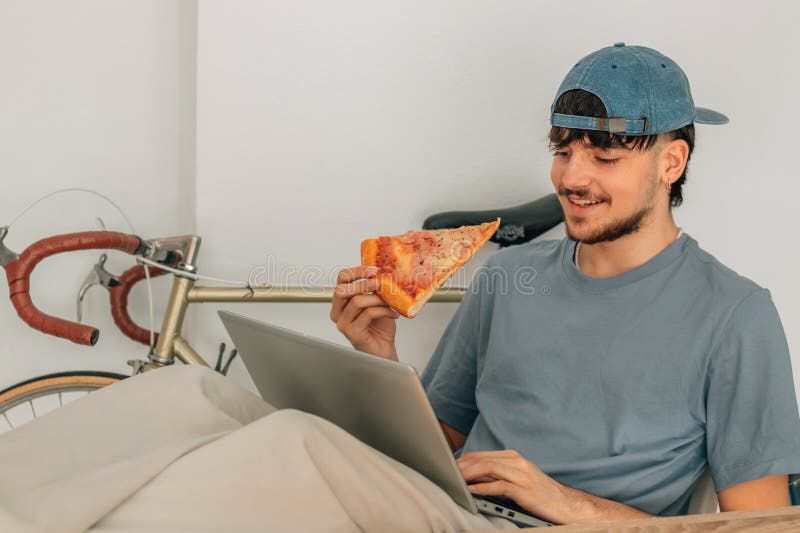Young Man at Desk with Computer Eating Pizza Stock Photo - Image of ...