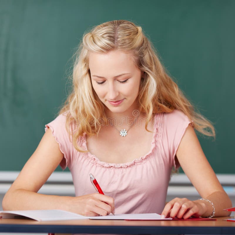 Schreibens-Studentin-with Classmates at-Schreibtisch Stockfoto - Bild ...