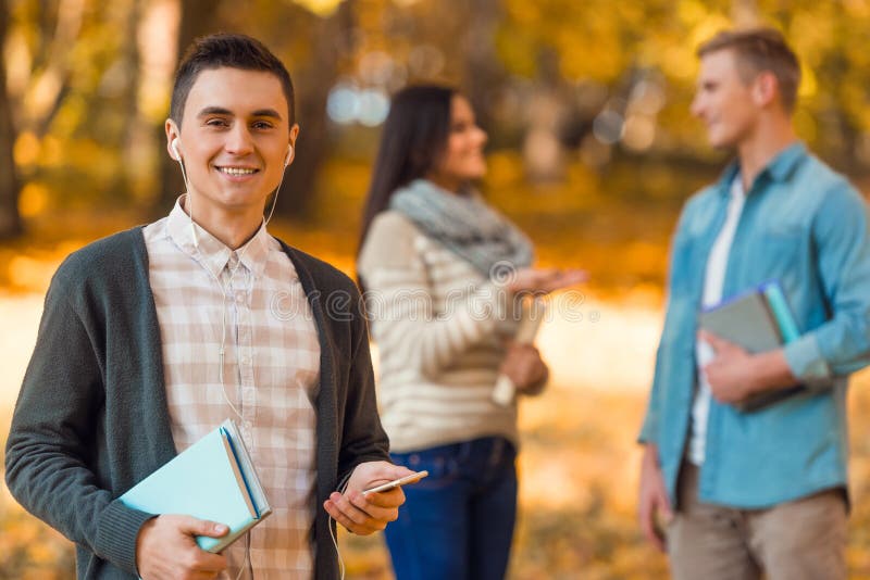 Students in autumn park stock image. Image of smartphone - 64433997