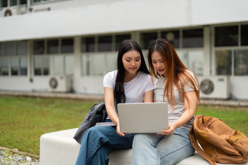 Students Collaborating on a Laptop, Focused on Their Studies in a Peaceful Outdoor Setting ...