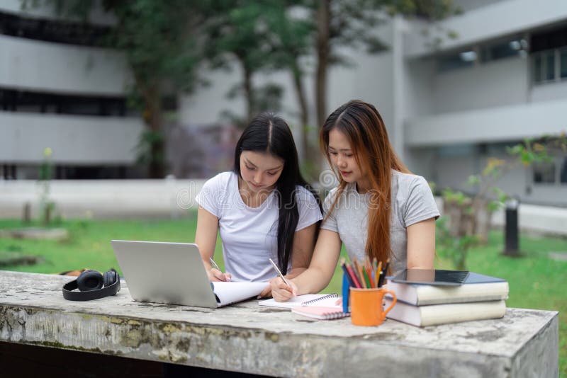 Students Collaborating on Studies Outdoors at University, Using a Laptop and Notebooks Stock ...