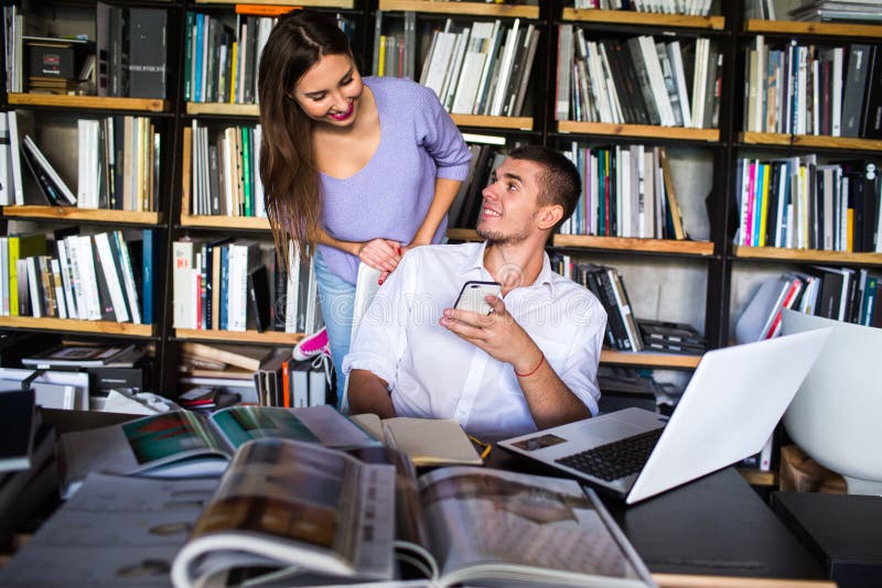 Students Communicate in a Library. Young Man and Woman Talking in the ...