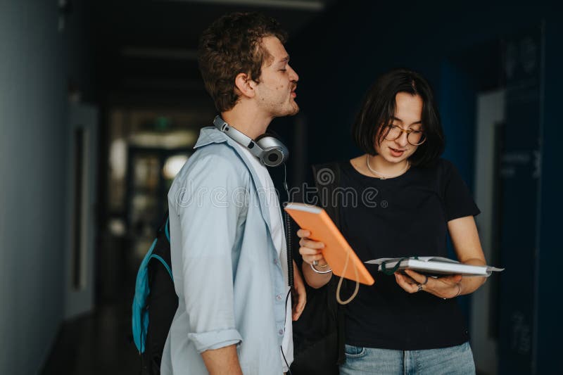 Students Discussing Course Notes in a University Hallway Setting Stock ...