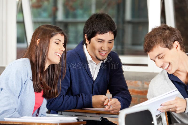 Students Discussing Over Book in Classroom Stock Photo - Image of ...