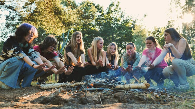 Students Gathering Around Campfire, Warming Hands during Forest Camping ...