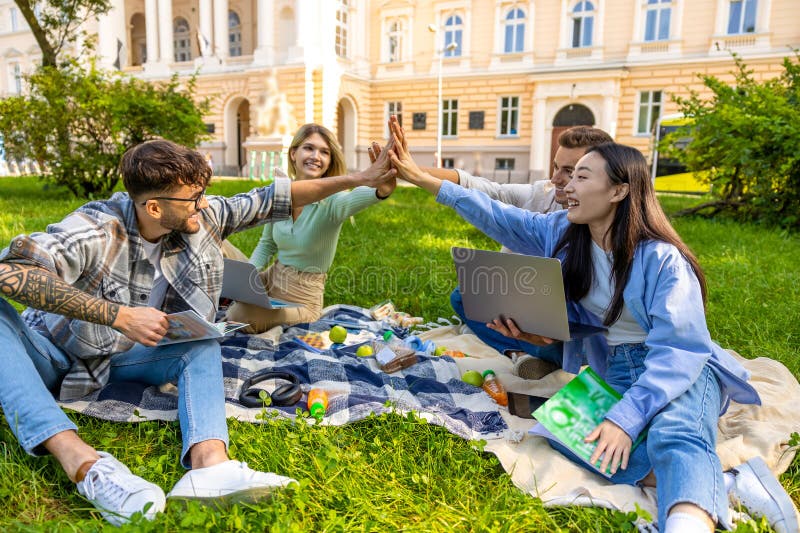Students Holding Hands while Sitting on Grass Working Together on ...