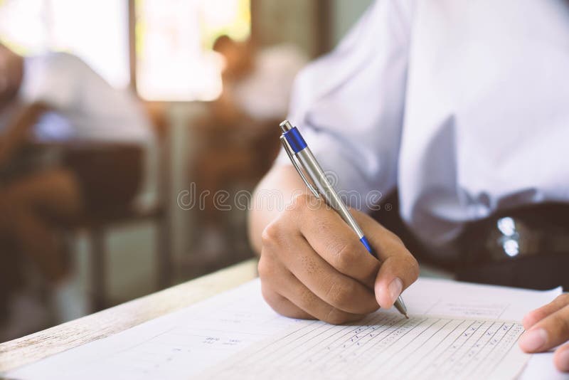 Students Holding Pen in Hand Doing Exams Answer Sheets Exercises in ...