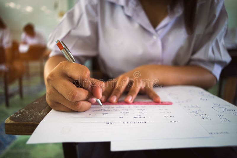 Students Holding Pen in Hand Doing Exams Answer Sheets Exercises in ...