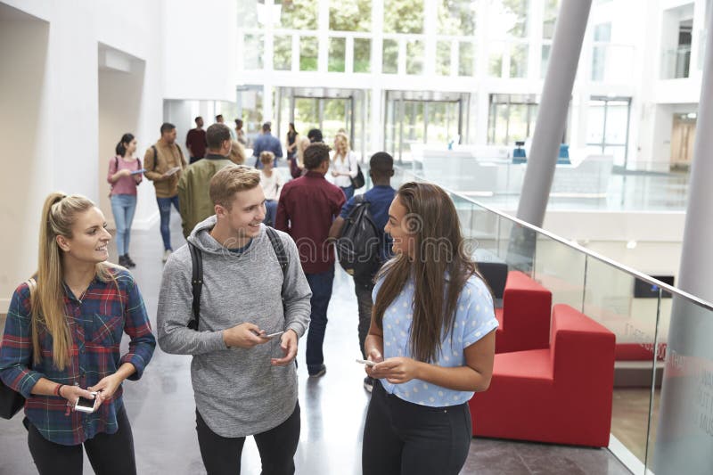 Students Holding Tablets and Phone Talk in University Lobby Stock Image ...