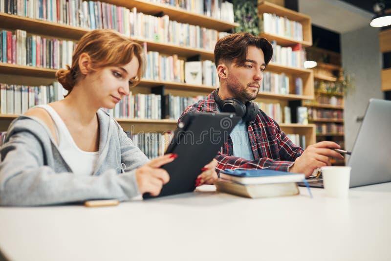 Student Learning in University Library. Young Woman Reading Textbook ...