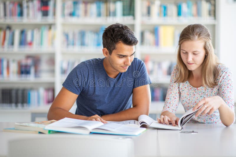 Students in a Library - Handsome Student Reading a Book Stock Photo ...