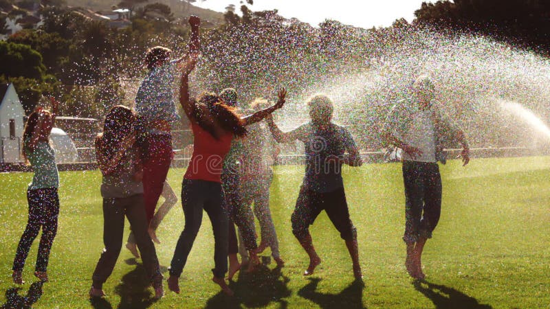 Students Messing Around in the Sprinklers on the Grass Stock Footage ...
