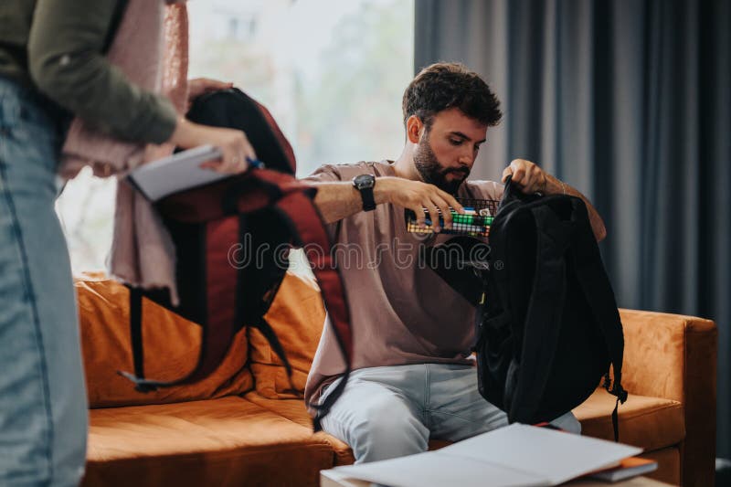 Students Organizing Backpacks on a Sofa for Study Session Stock Photo ...