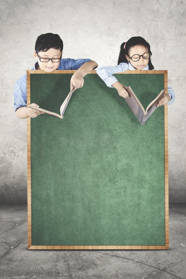 Students Reading Books Behind a Chalkboard Stock Photo - Image of copy ...