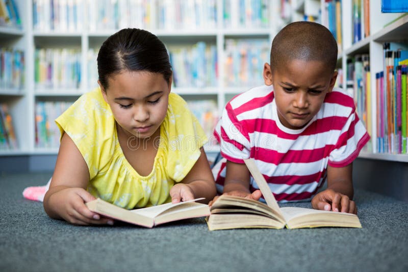 Students Reading Books while Lying at Library in School Stock Image ...