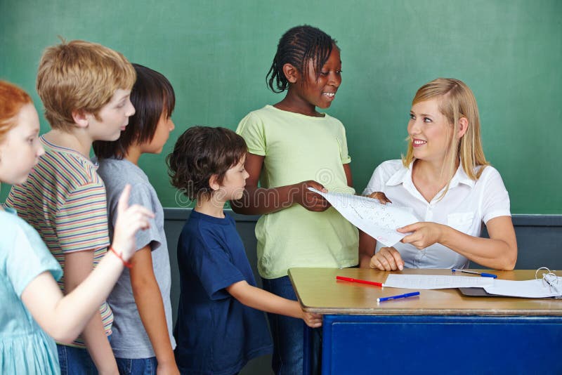 Students in a Row at Desk of Teacher Stock Image - Image of assessment ...