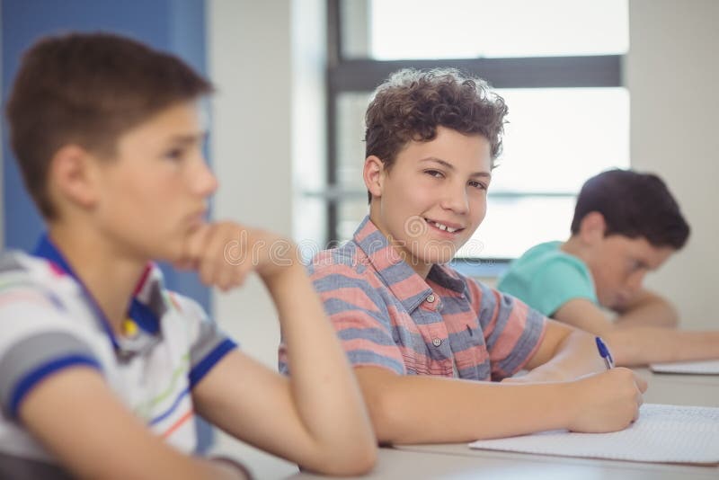 Students Sitting at Desk in Classroom Stock Image - Image of ...