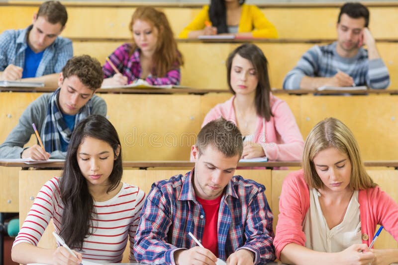 Students Sitting at the Lecture Hall while Writing Stock Photo - Image ...