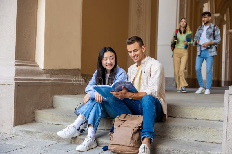 Students Sitting on Stairs in Campus Preparing for Classes Together ...