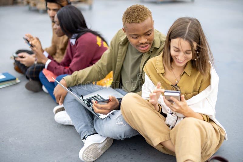 Students Sitting and Using Gadgets on Asphalt Stock Photo - Image of ...