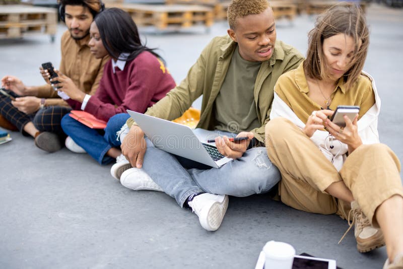 Students Sitting and Using Gadgets on Asphalt Stock Image - Image of ...
