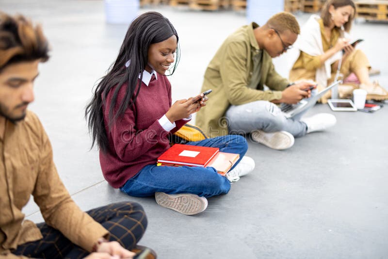 Students Sitting and Using Smartphones on Asphalt Stock Photo - Image ...