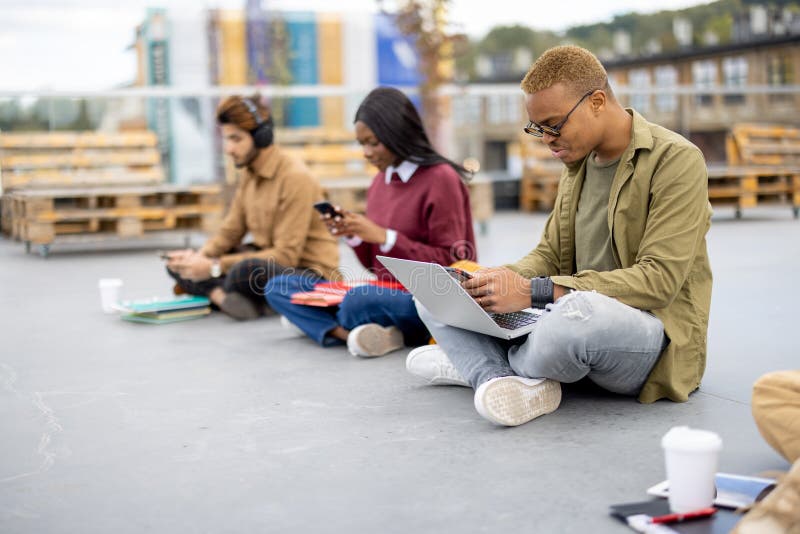 Students Sitting and Using Smartphones on Asphalt Stock Photo - Image ...