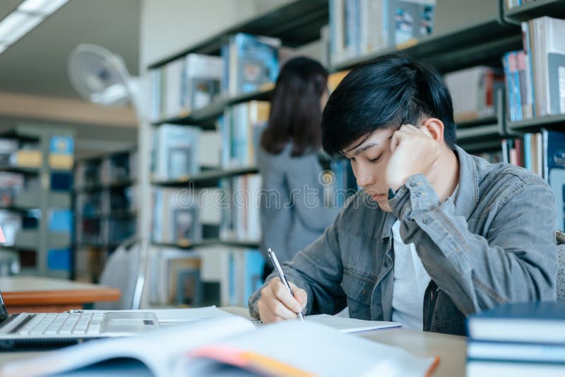 Students Studying in the Library with Laptop and Book at the University ...