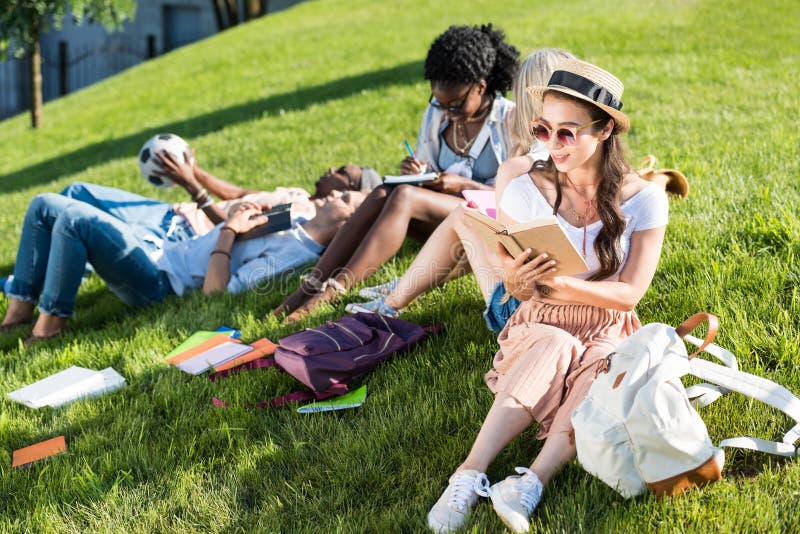 Students Studying and Resting on Green Grass in Park Stock Photo ...