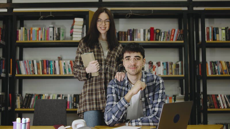 Students Studying Together in a Library with Bookshelves Filled with ...