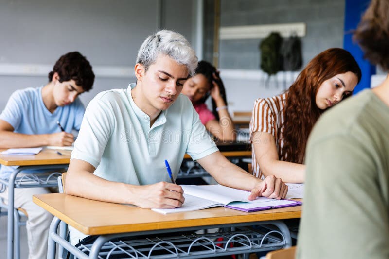 Students Taking Notes while Listening Teacher in Classroom at High ...