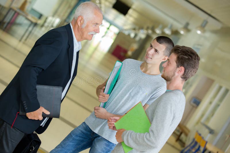 Students Talking To Lecturer in Lobby Stock Image - Image of ...