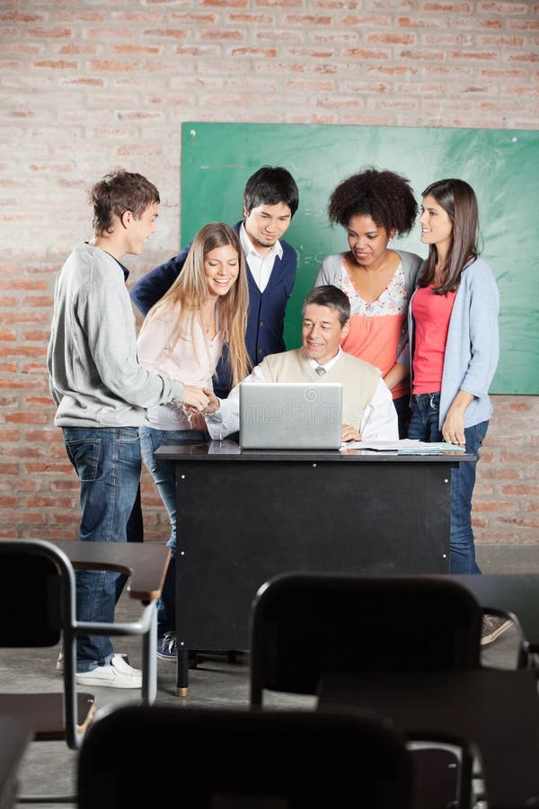Teacher with Laptop Explaining Lesson To Students Stock Photo - Image ...