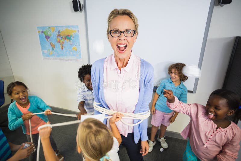 Students Tying Up a Teacher with Rope in Classroom Stock Image - Image ...