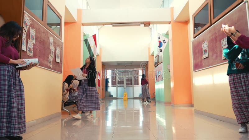 Students in Uniforms Chatting and Reading Books in a Brightly Lit ...