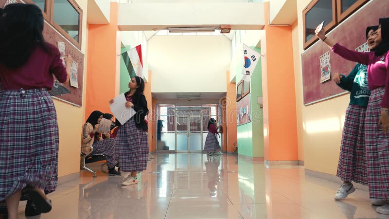 Students in Uniforms Chatting and Reading Books in a Brightly Lit ...