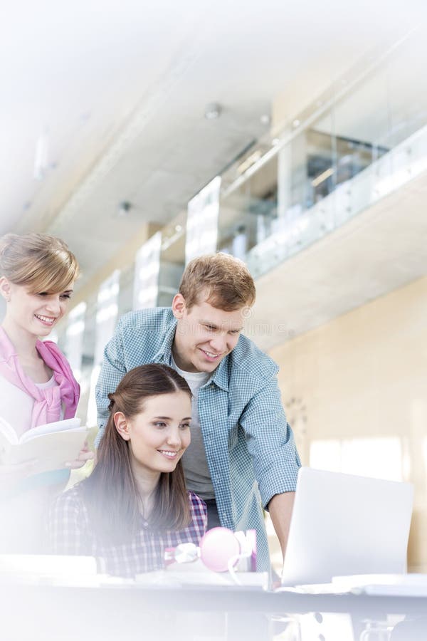 Smiling Students Doing Assignment at Table in University Stock Photo ...
