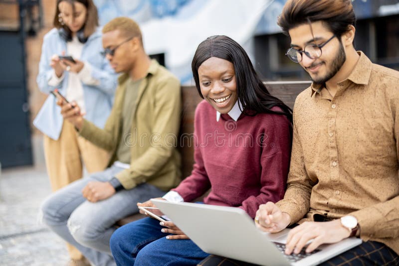 Students Using Digital Devices on Wooden Bench Stock Image - Image of ...