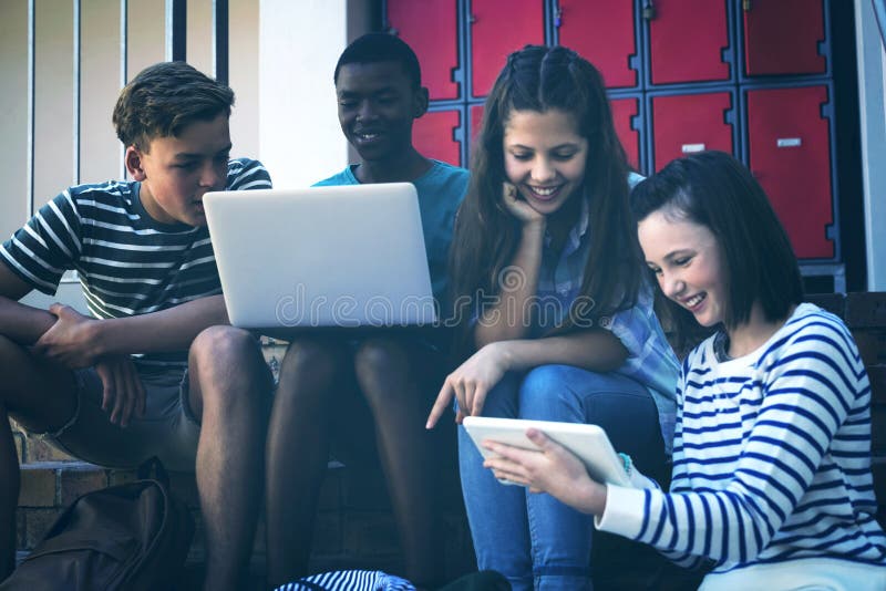 Students Using Laptop, Mobile Phone and Digital Tablet on Staircase ...