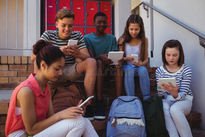 Students Using Mobile Phone and Digital Tablet on Staircase Stock Photo ...