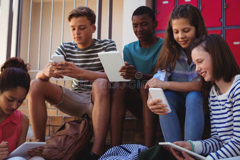 Students Using Mobile Phone and Digital Tablet on Staircase Stock Photo ...
