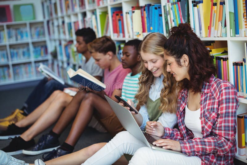 Students Using Mobile Phone and Laptop in Library Stock Image - Image ...