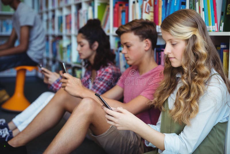 Students Using Mobile Phone in Library Stock Image - Image of female ...