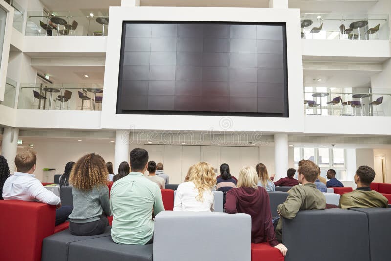 Students Watching Big Screen in University Atrium, Back View Stock ...