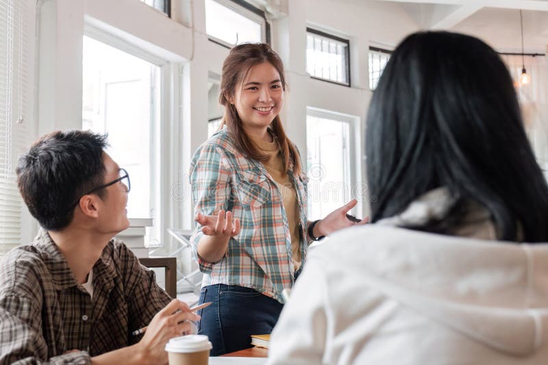 Diverse Group of Students Collaborating on Homework in a Bright Modern ...