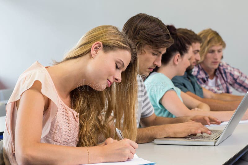 Students Writing Notes in Classroom Stock Image - Image of book ...