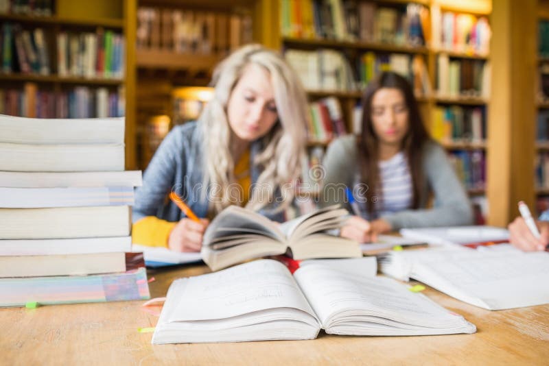 Students Writing Notes with Stack of Books at Library Desk Stock Image ...