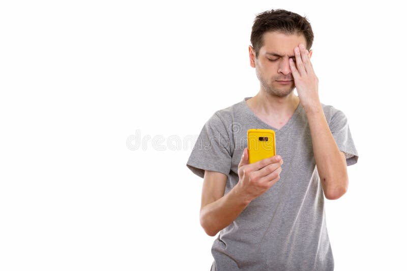 Studio Shot of Young Man Using Mobile Phone while Looking Stress Stock ...