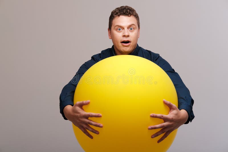 Studio Portrait of Man Posing with Big Yellow Ball Stock Photo - Image ...